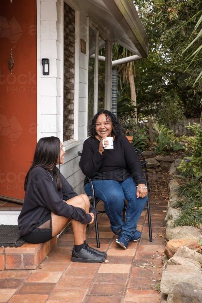 Image of Aboriginal mum sitting with teen daughter on back porch ...