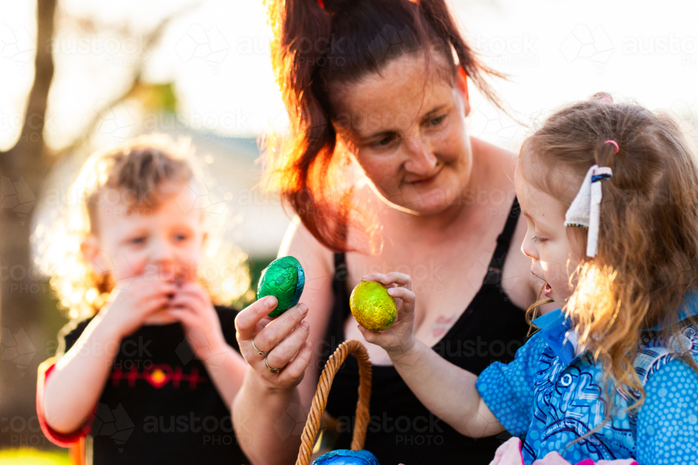 Image of Aboriginal mum with foil wrapped chocolate easter eggs and two ...