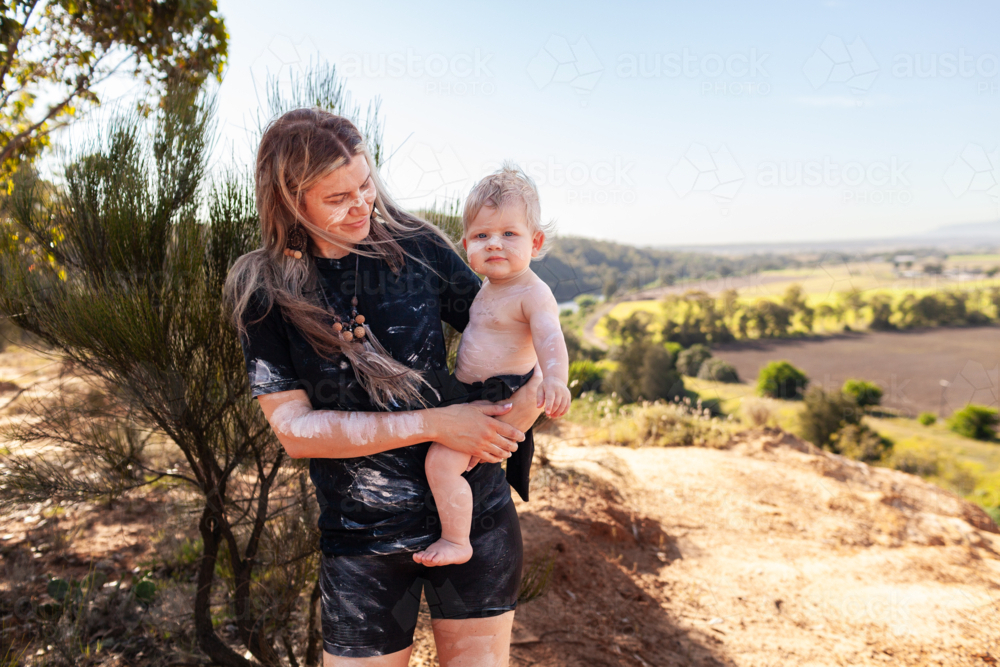 Image of Aboriginal mum with her baby boy together by cliff on country ...
