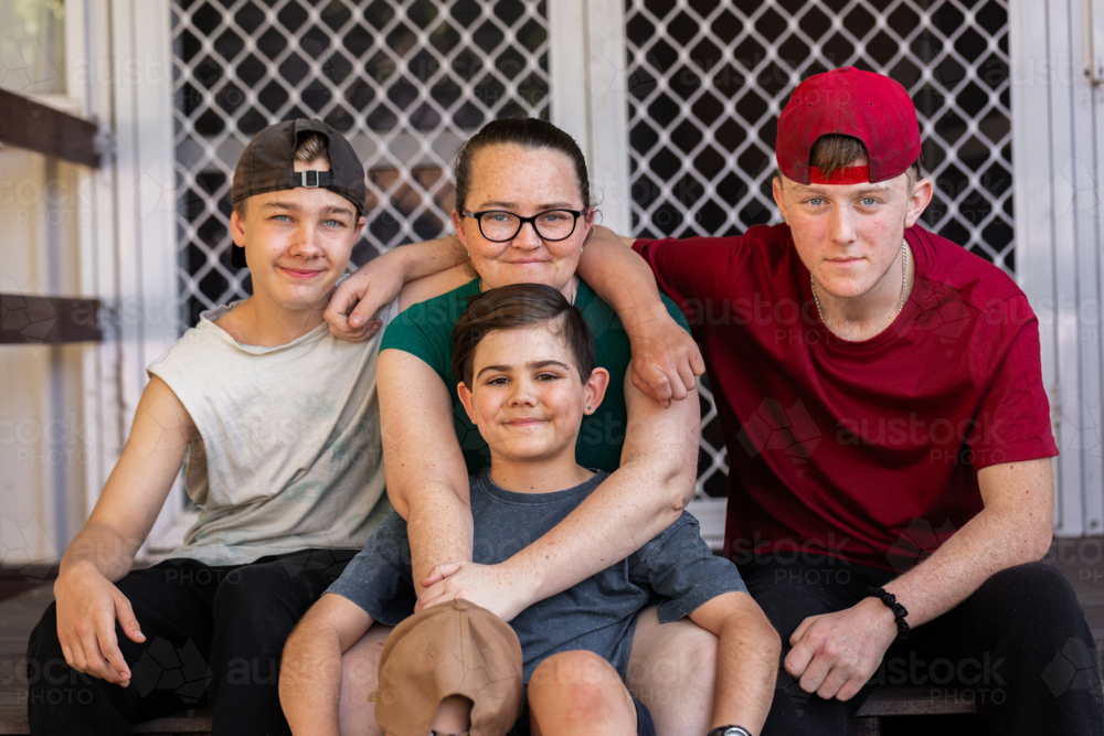 Image of Aboriginal mum with teen and pre-teen sons sitting together on ...