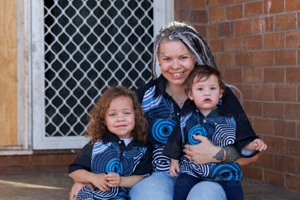 Image of Aboriginal mum with two young daughters sitting together on ...
