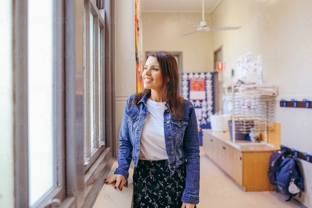 Image of Aboriginal school teacher standing looking out the window ...