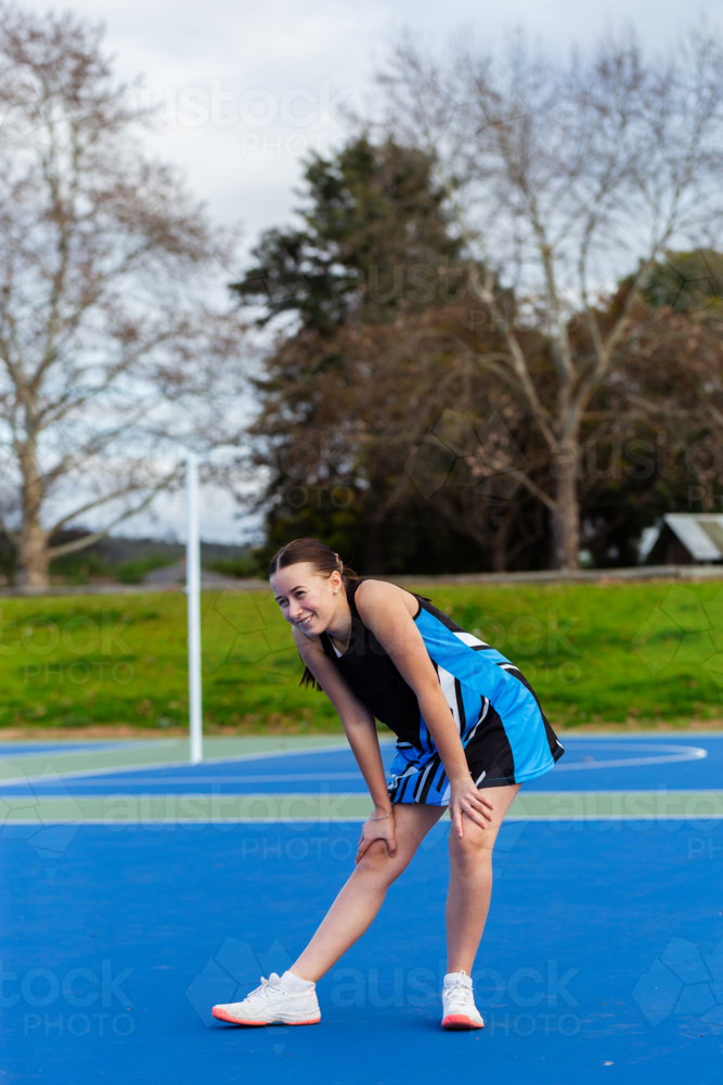 Image of Aboriginal teen netball player doing stretches to warm up ...