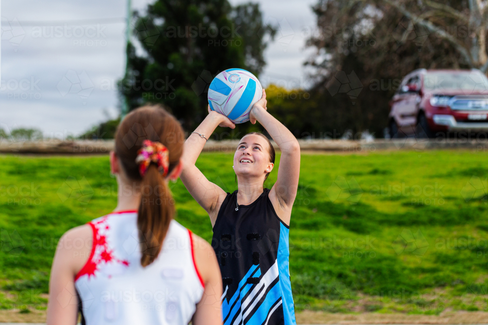 Image of Aboriginal teenager playing netball game shooting for the goal ...