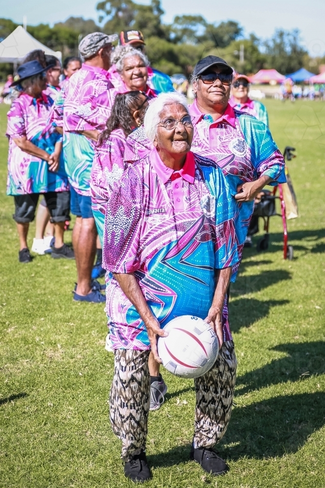 Image of Aboriginal woman crouching to throw netball - Austockphoto