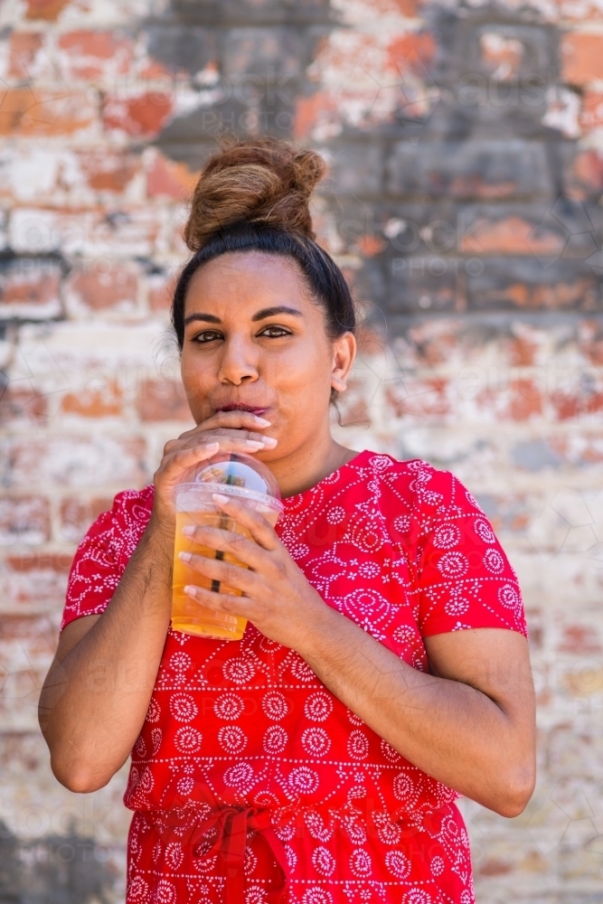 Image of aboriginal woman drinking juice - Austockphoto