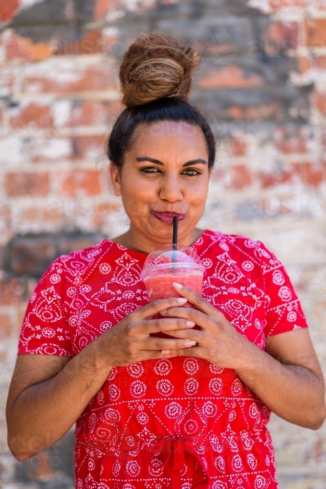 Image of aboriginal woman drinking juice - Austockphoto