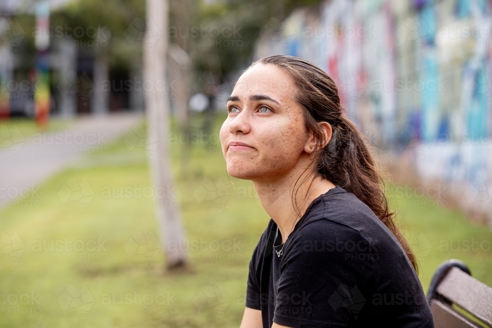 Image of Aboriginal woman looking beyond the trees thinking positively ...