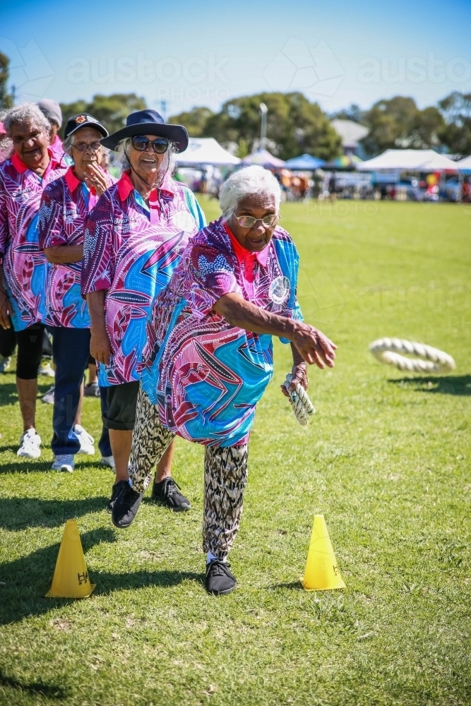 Image of Aboriginal woman throwing rope ring quoits standing between ...