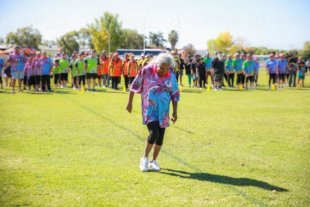 Image of Aboriginal woman walking relay while teams watch - Austockphoto