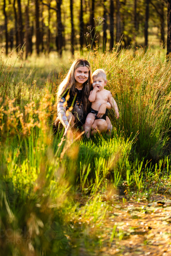 Image of Aboriginal woman with her eight month old baby boy crouched ...
