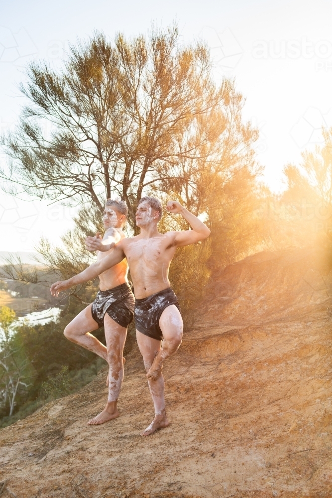 Image of Aboriginal young men pose in dance move on edge of cliff in ...