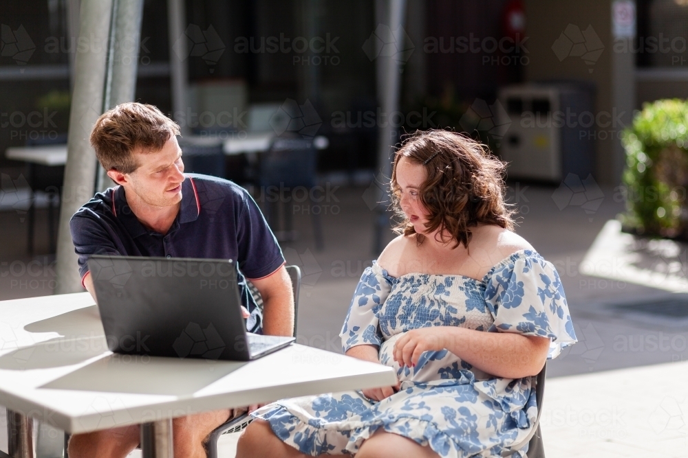 Image of Adult and teenager talking together at outdoor café with ...