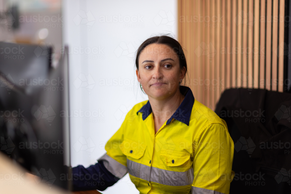Image of adult woman in high visibility clothes working in front of her ...