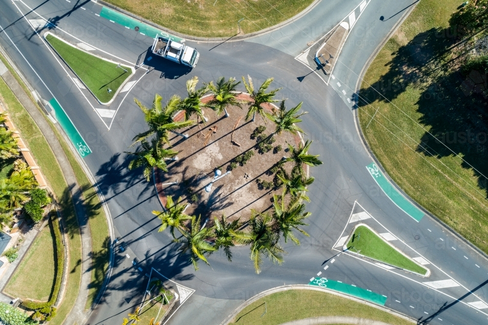 Image of Aerial drone view of work ute entering a roundabout with palm ...