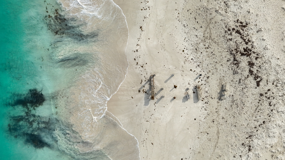 Image of Aerial of old jetty posts in the sand at a beach - Austockphoto