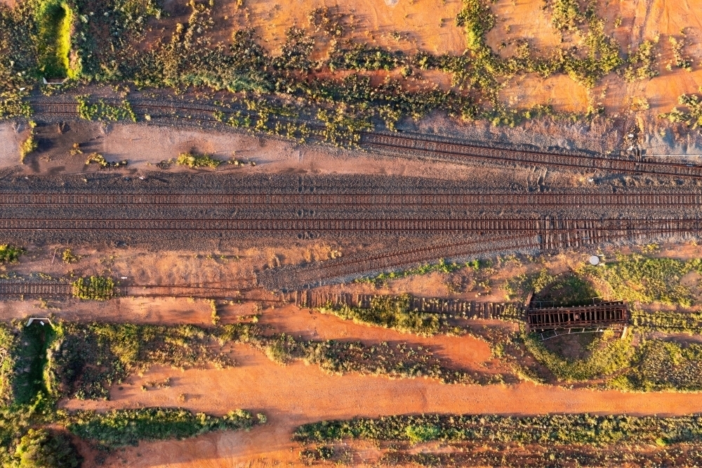Image of Aerial of railway tracks running through red dirt and green ...