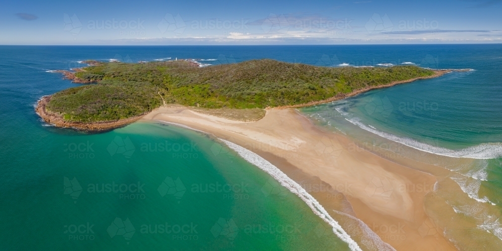 Image of Aerial panorama of a sand spit leading out to a forested ...