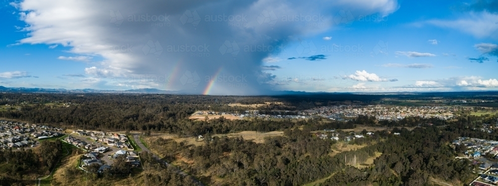 Image of Aerial panorama of double rainbows and rain cloud over edge of ...