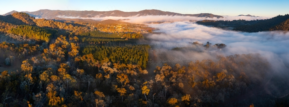 Image of Aerial panorama of fog filling a valley below a distant ...