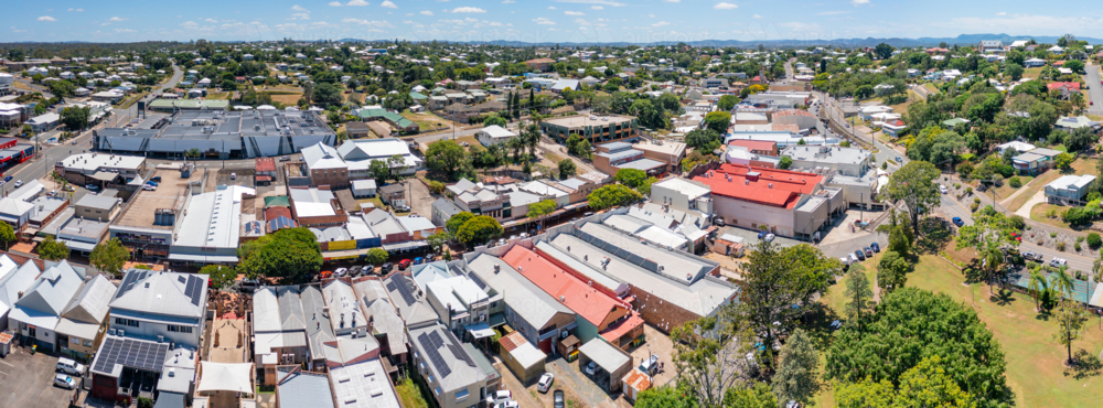 Image of Aerial panorama, of shops and rooftops along a main street ...