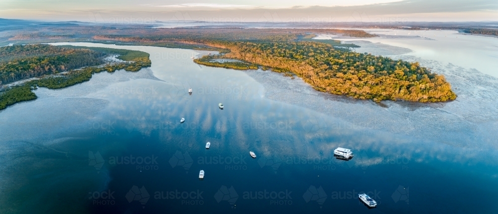 Image of Aerial panorama view of boats at anchor in estuary. - Austockphoto