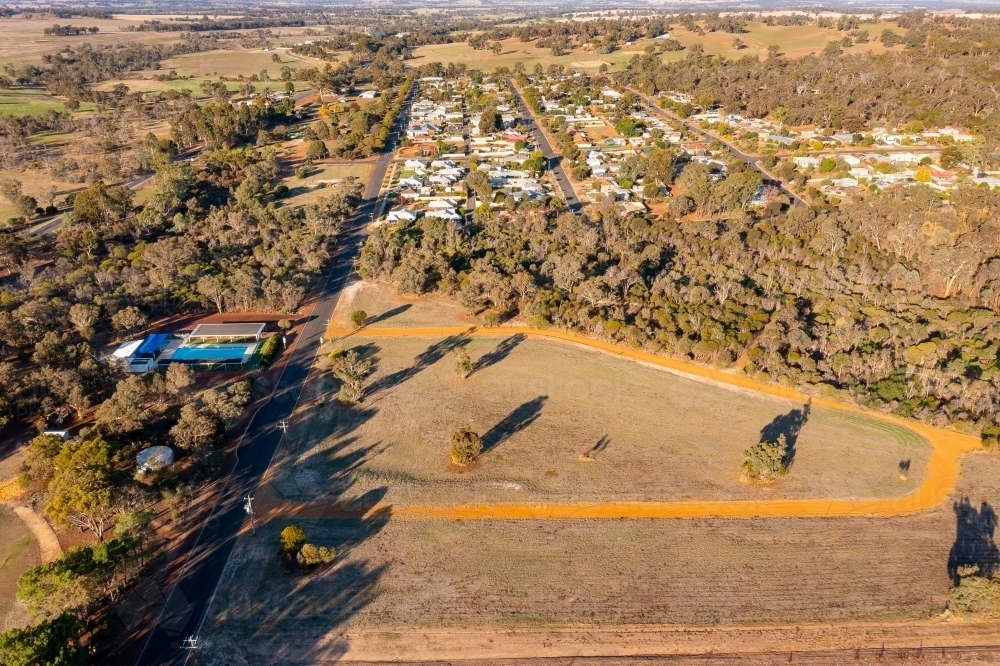 Image of Aerial shot of an open field with small buildings and road ...