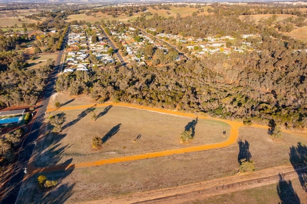 Image of Aerial shot of an open field with small buildings and road ...