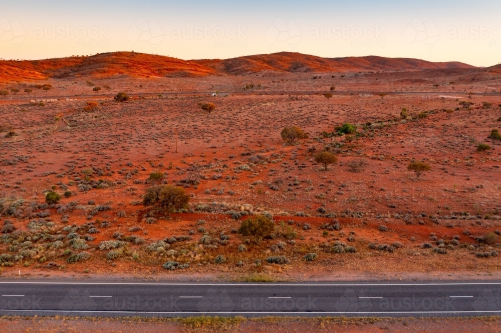 Image of Aerial view an outback highway cutting through a arid orange ...