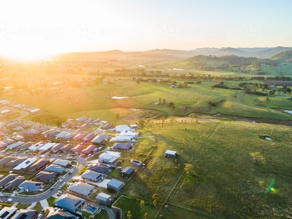 Image of Aerial view at sunset over houses at the edge of town with ...