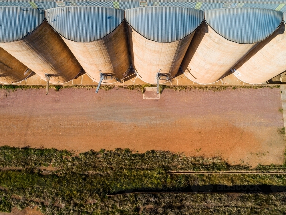 Image of Aerial view looking down on rural silos in a row beside ...