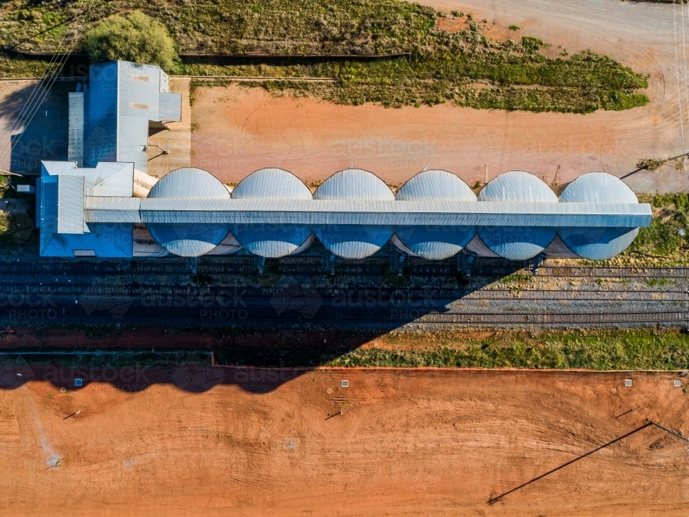Image of Aerial view looking down on rural silos in a row beside ...