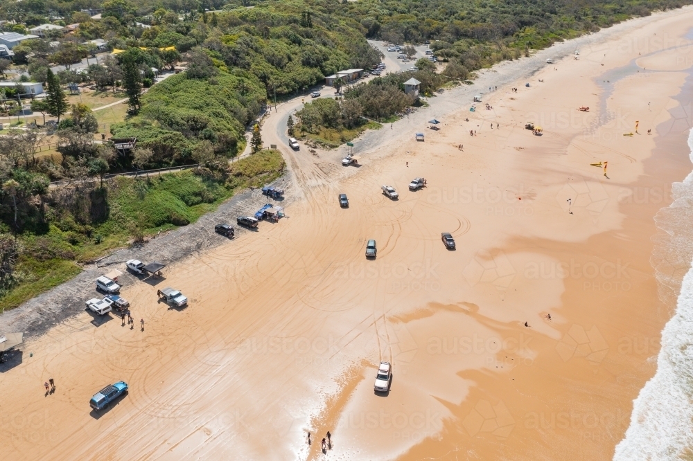 Image of Aerial view of 4WDs parked on a long sandy beach - Austockphoto