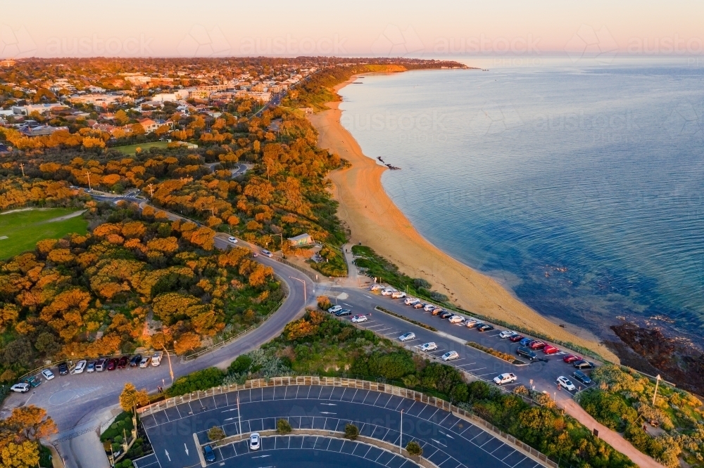 Image of Aerial view of a bay side beach and carpark in late afternoon ...