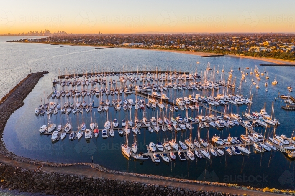 Image of Aerial view of a bay side marina with rows of boats tied to ...