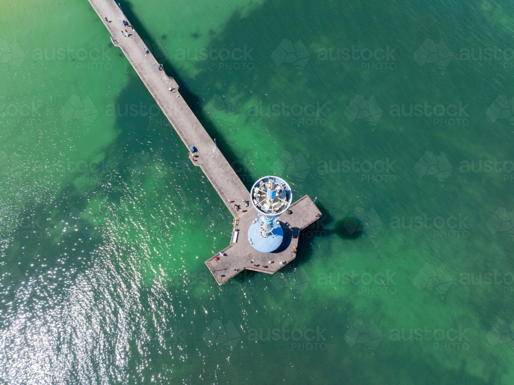 Image of Aerial view of a beacon tower on the end of a coastal pier ...