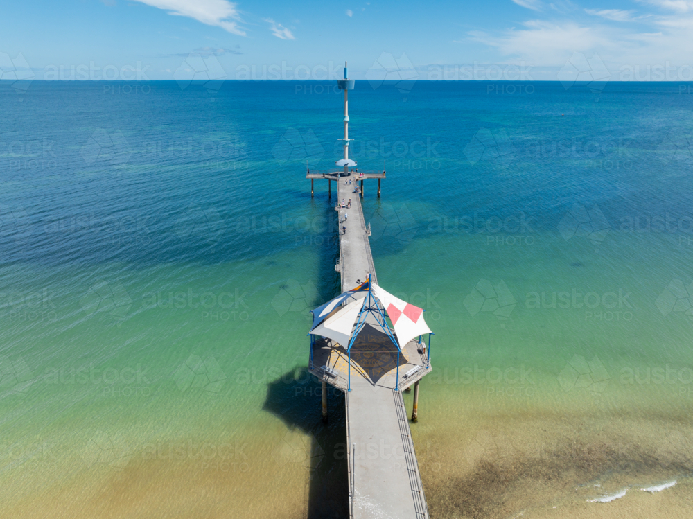 Image of Aerial view of a beacon tower on the end of a coastal pier ...