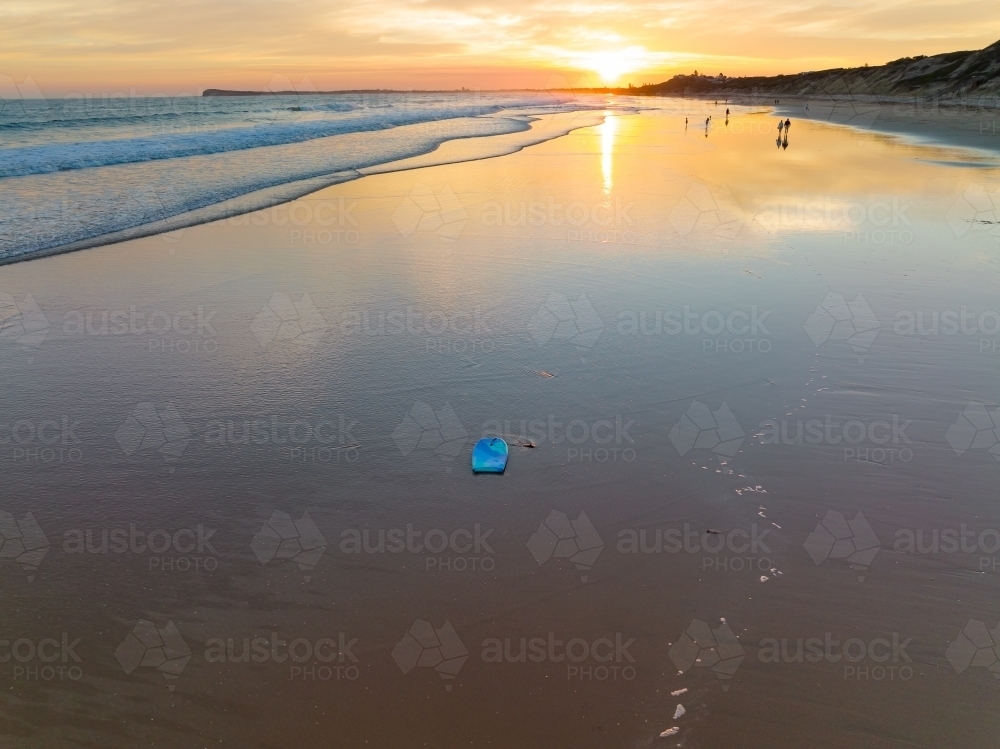 Image of Aerial view of a boogie board and gentle waves on a beach with ...