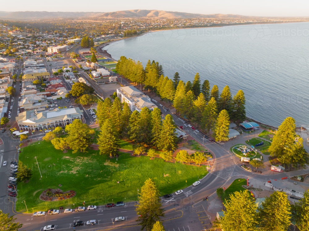 Image of Aerial view of a busy coastal esplanade lined with trees and ...