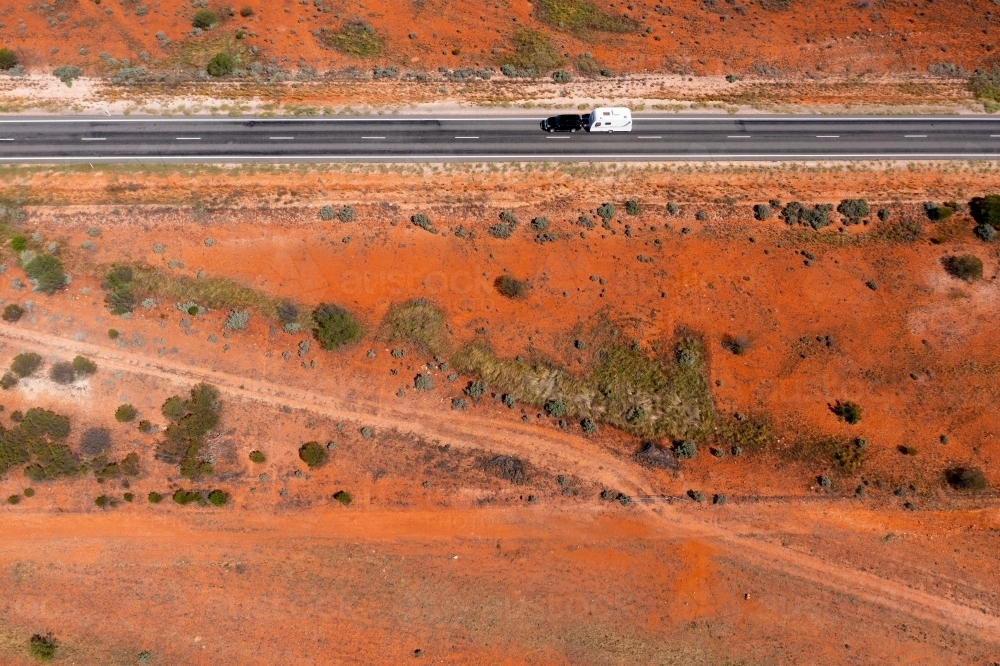Image of Aerial view of a car towing a caravan along a straight road ...