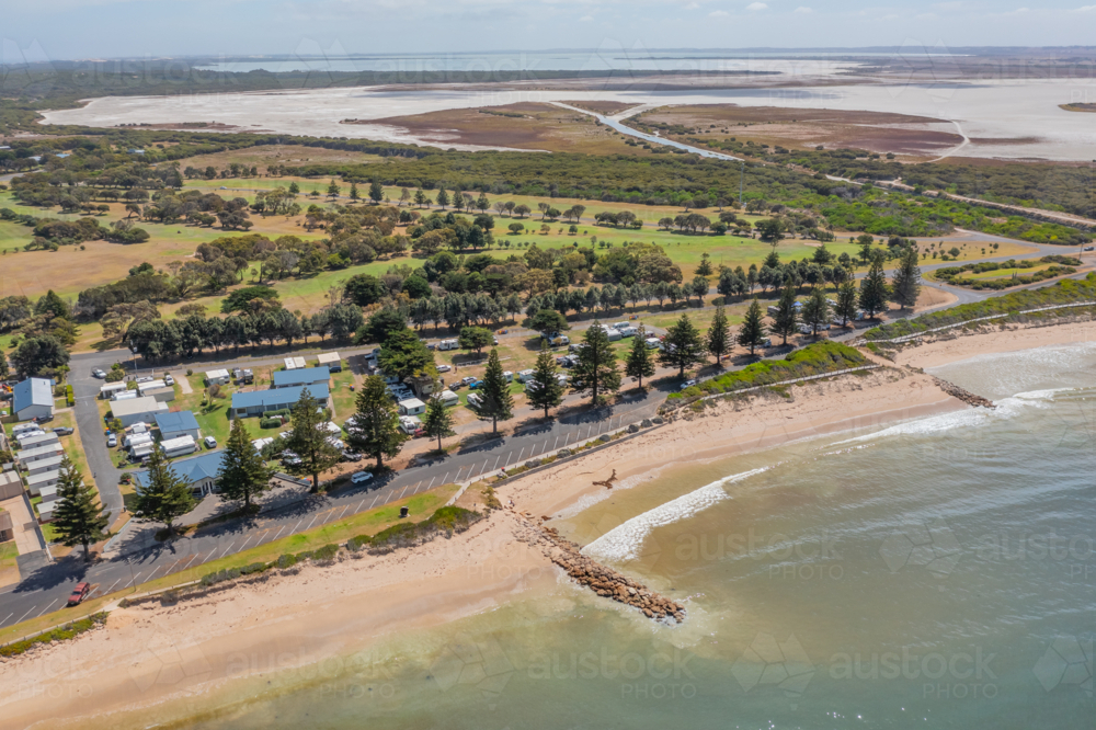 Image of Aerial view of a caravan park behind a coastal beach with salt ...