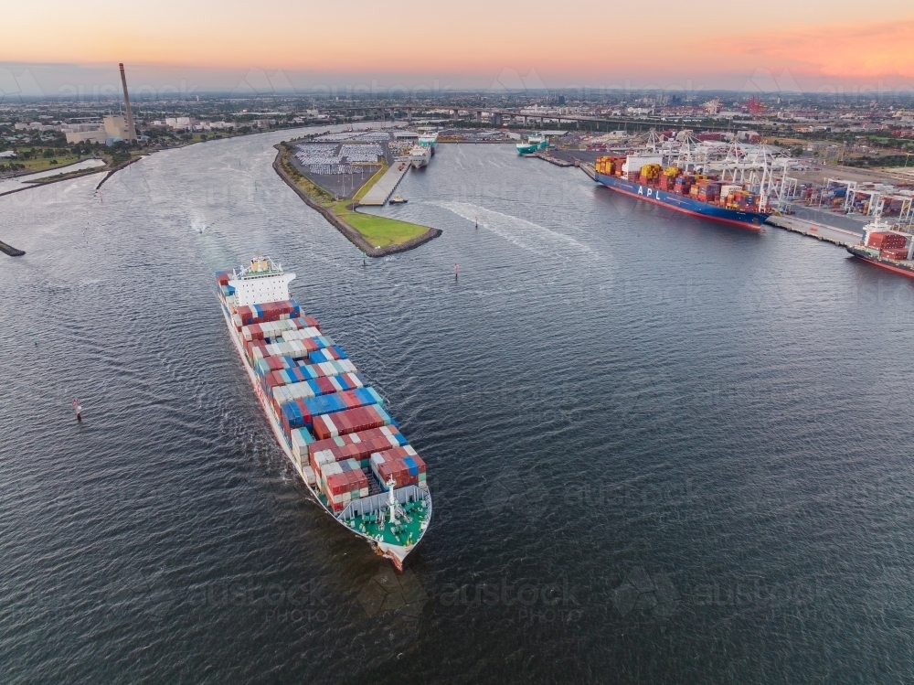 Image of Aerial view of a cargo ship leaving port fully laden with ...