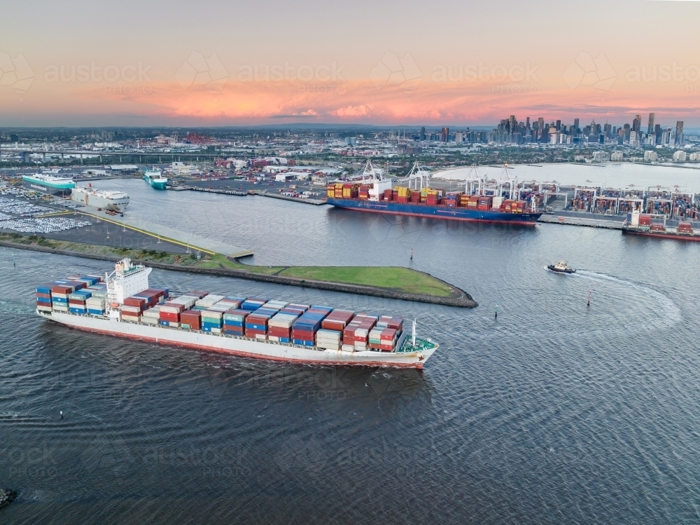 Image of Aerial view of a cargo ship leaving port fully laden with ...