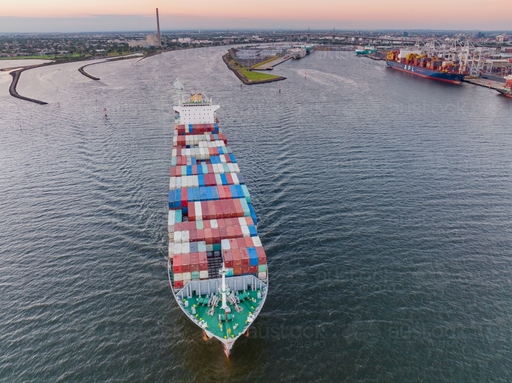 Image of Aerial view of a cargo ship leaving port fully laden with ...