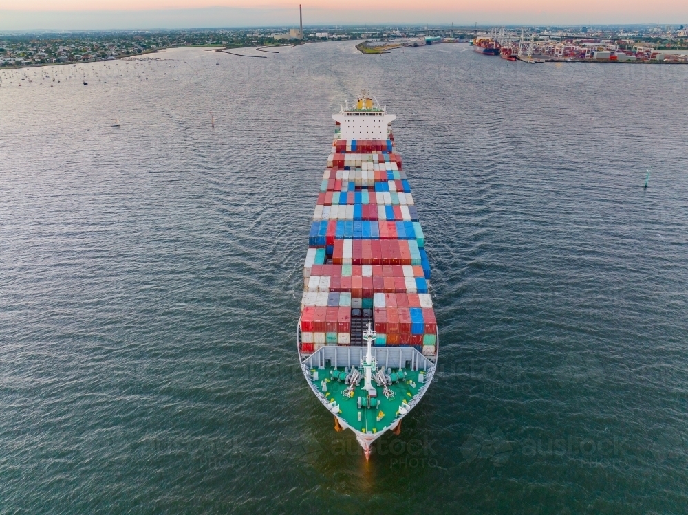 Image of Aerial view of a cargo ship leaving port fully laden with ...