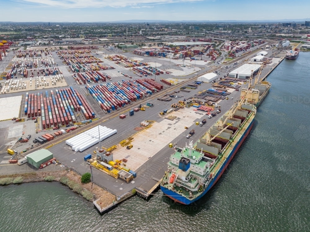 Image of Aerial view of a cargo ship with its holds open at wharf lined ...