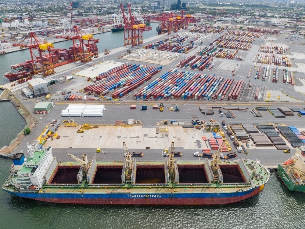 Image of Aerial view of a cargo ship with its holds open at wharf lined ...