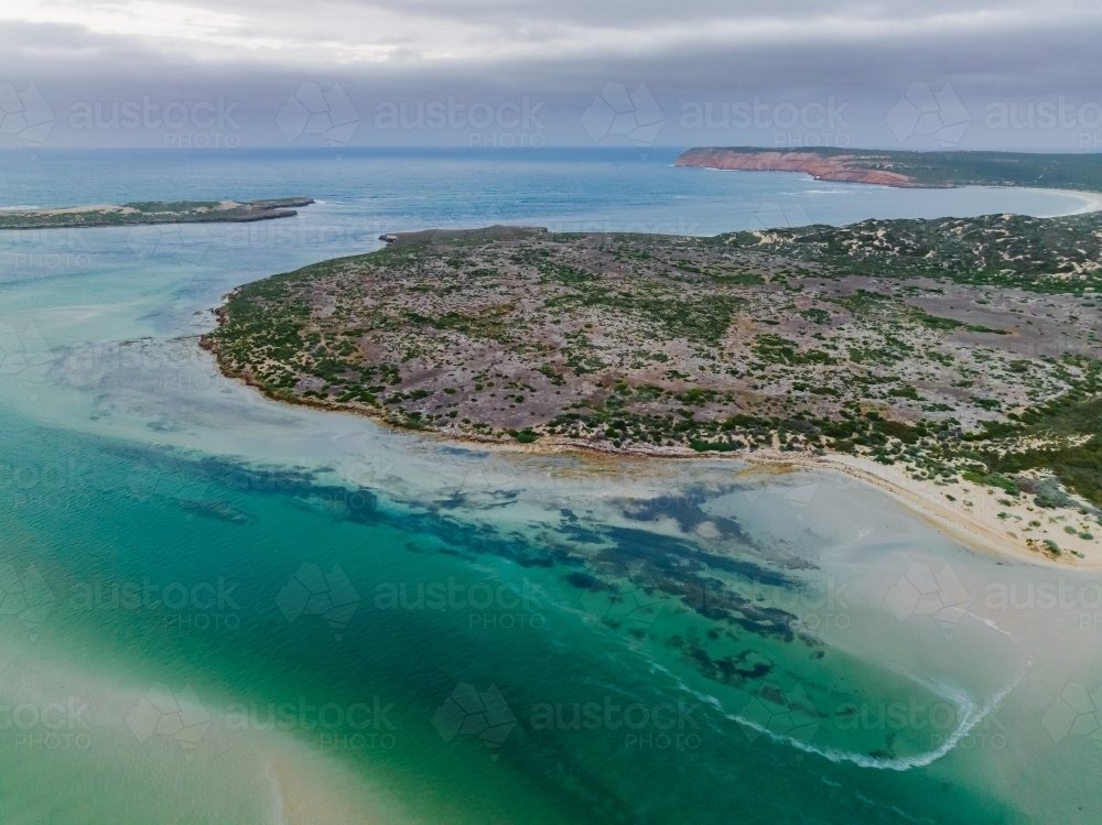 Image of Aerial view of a coastal bay winding out to sea past islands ...