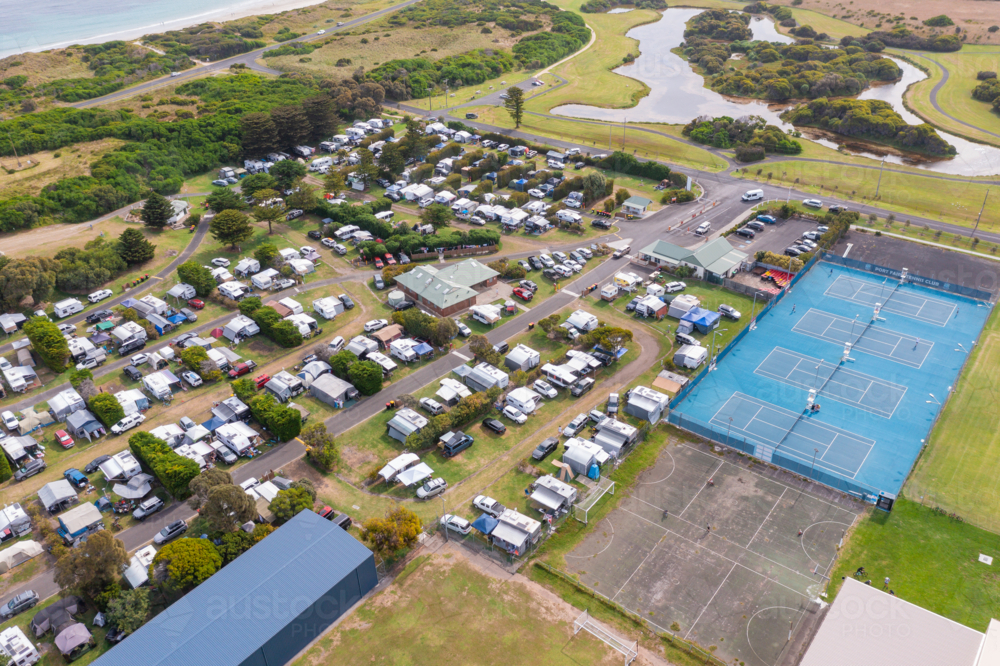 Image of Aerial view of a coastal caravan park alongside tennis courts ...