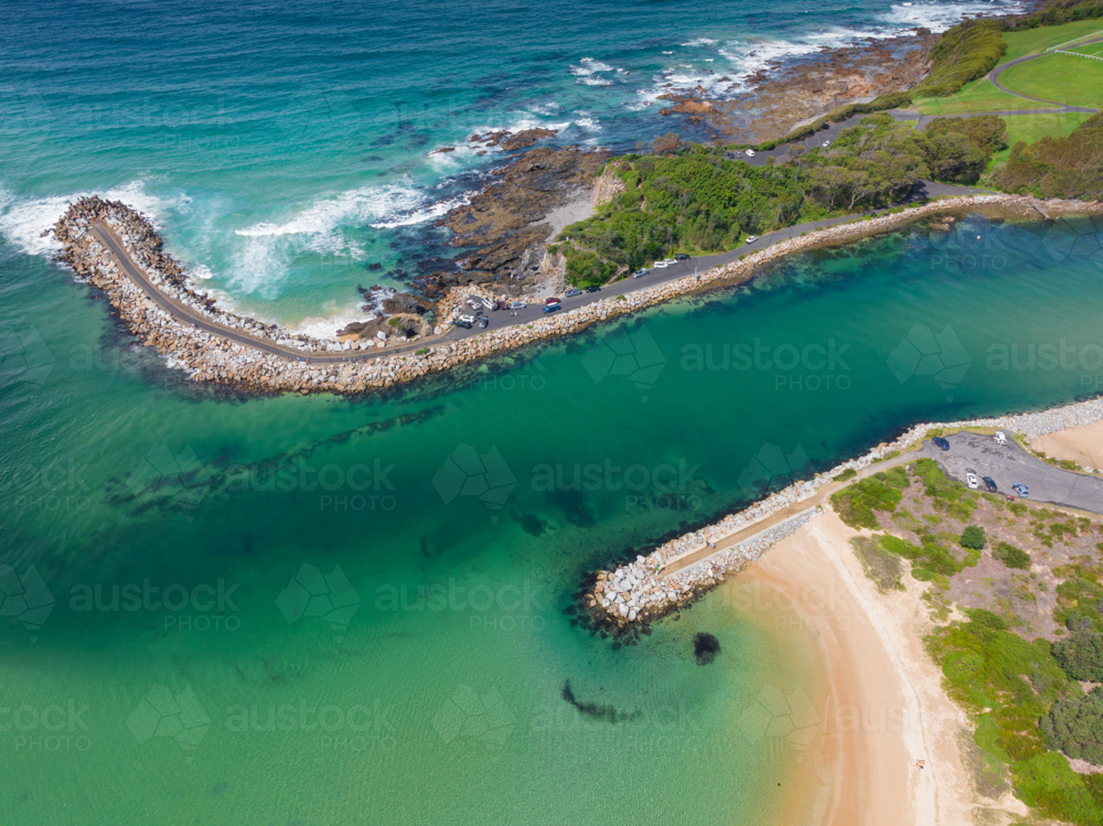 Image of Aerial view of a coastal inlet flowing out to sea between two ...